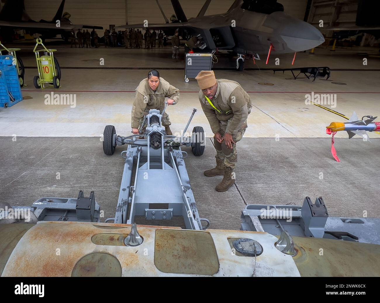 A 43rd Fighter Generation Squadron team guides a manual weapon lifter ...