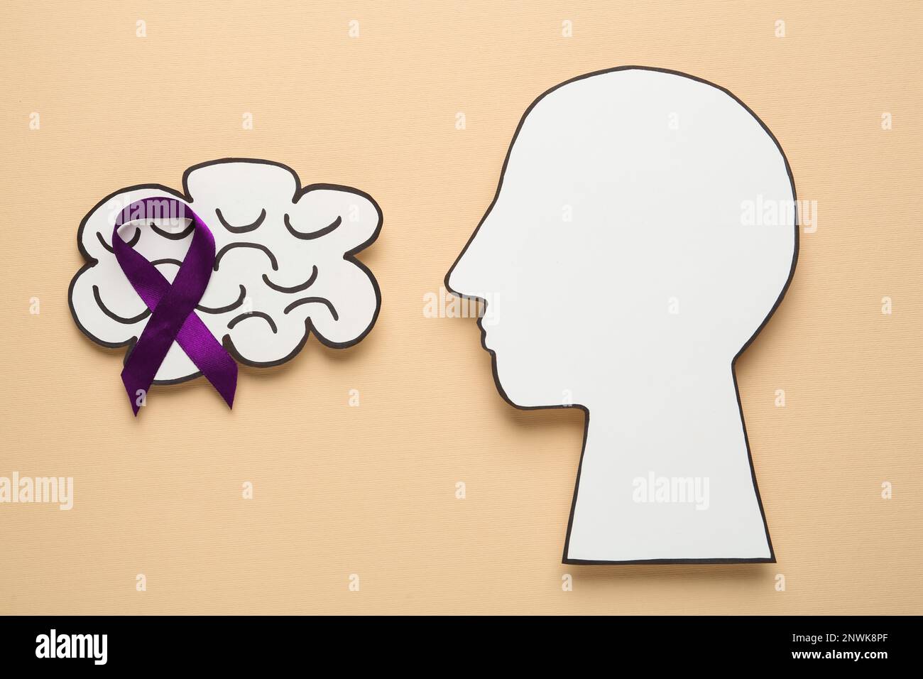 Human head and brain cutouts with purple ribbon on yellow background ...