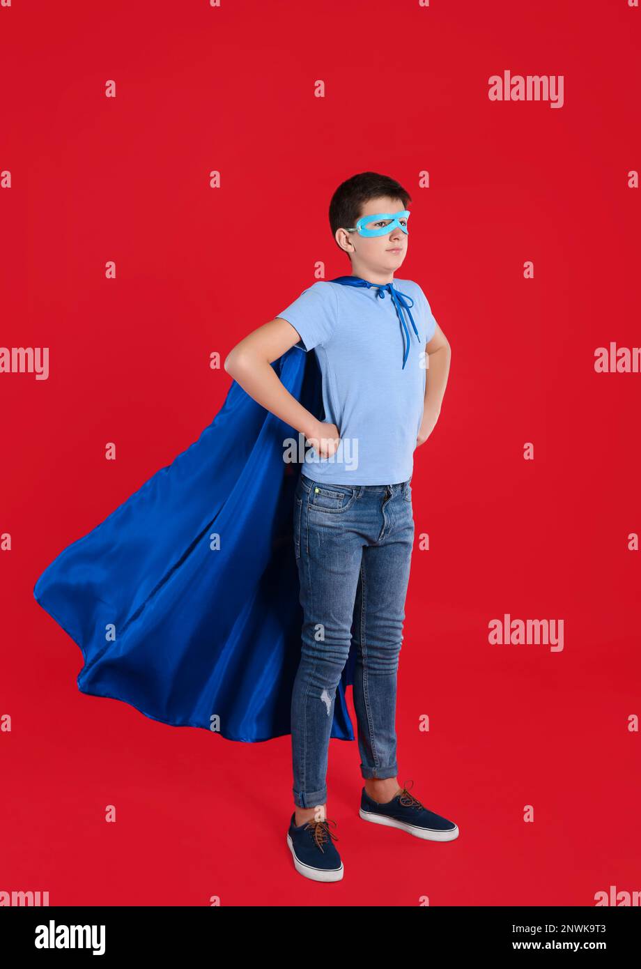 Teenage boy in superhero costume on red background Stock Photo - Alamy