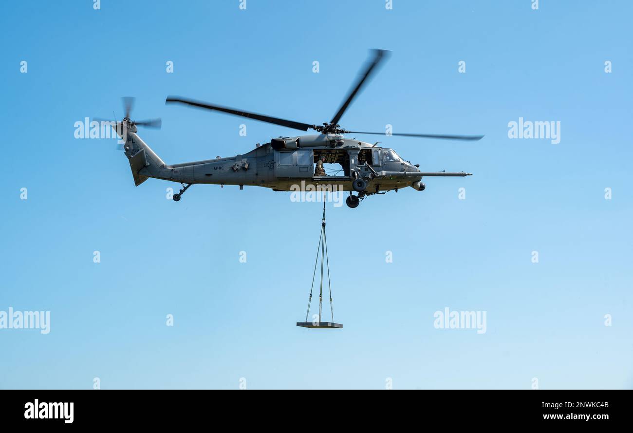 A 301st Rescue Squadron HH-60G Pave Hawk helicopter hovers with sling ...