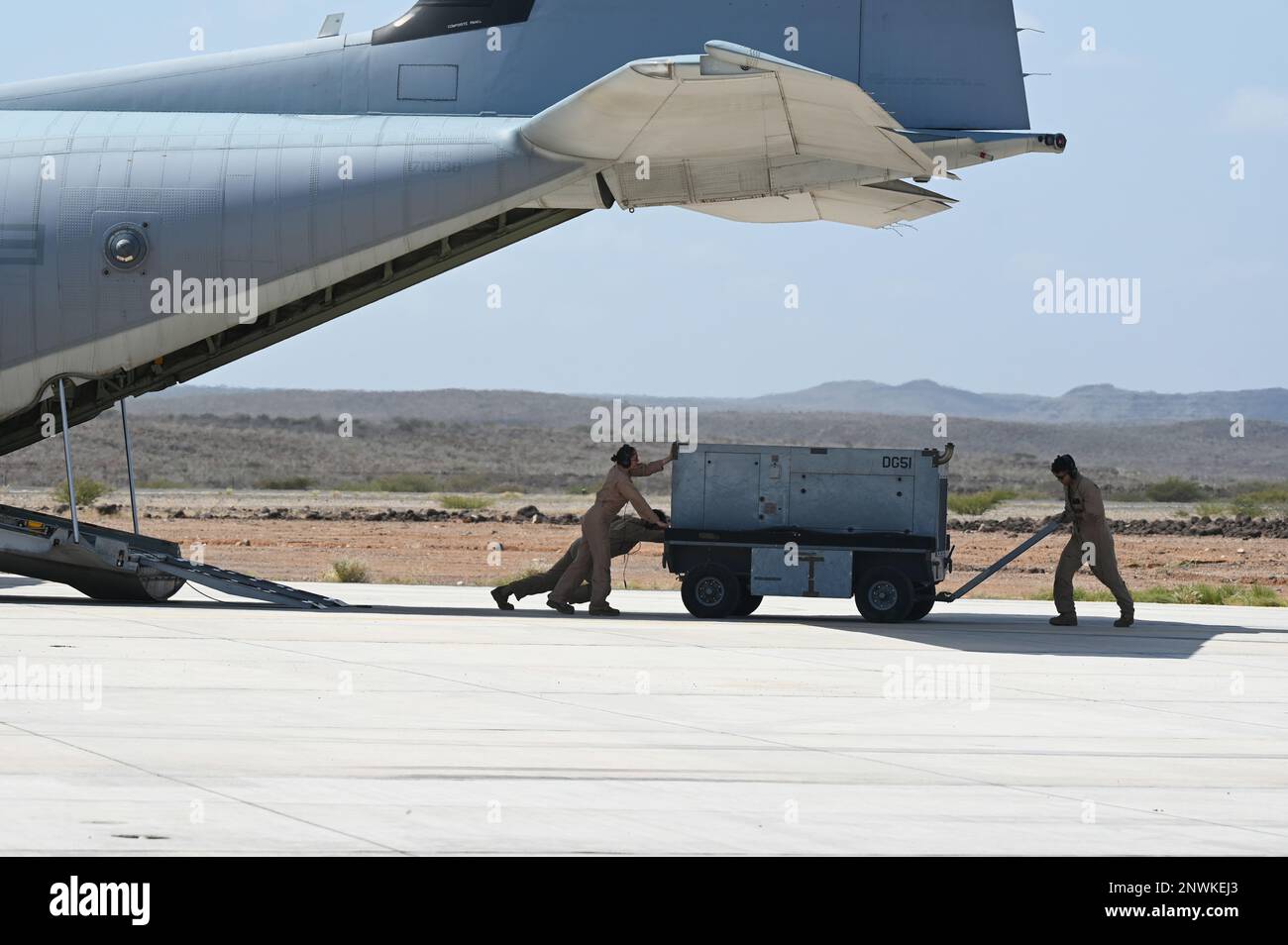 U.S. Marine Corps KC-130 crew members unload supplies in support of a ...