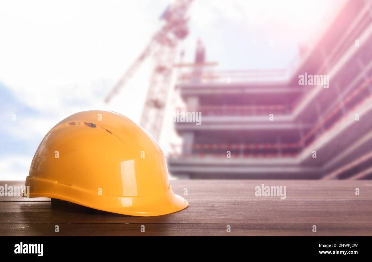 Hard hat on wooden surface at construction site with unfinished ...