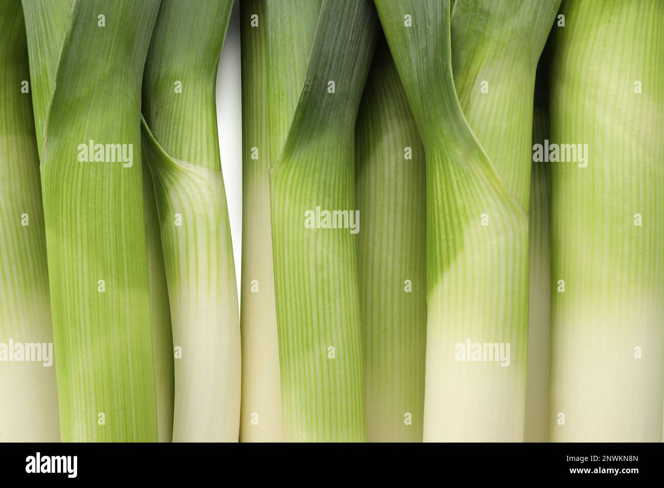 Fresh raw leeks as background, top view Stock Photo - Alamy