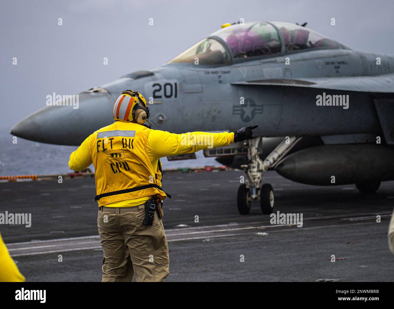 230105-N-MH015-1062 PHILIPPINE SEA (Jan. 5, 2023) A U.S. Navy Sailor directs an F/A-18E Super ...
