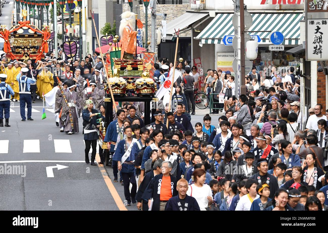 Participants parade with the portable shrine, a float, horses and ...