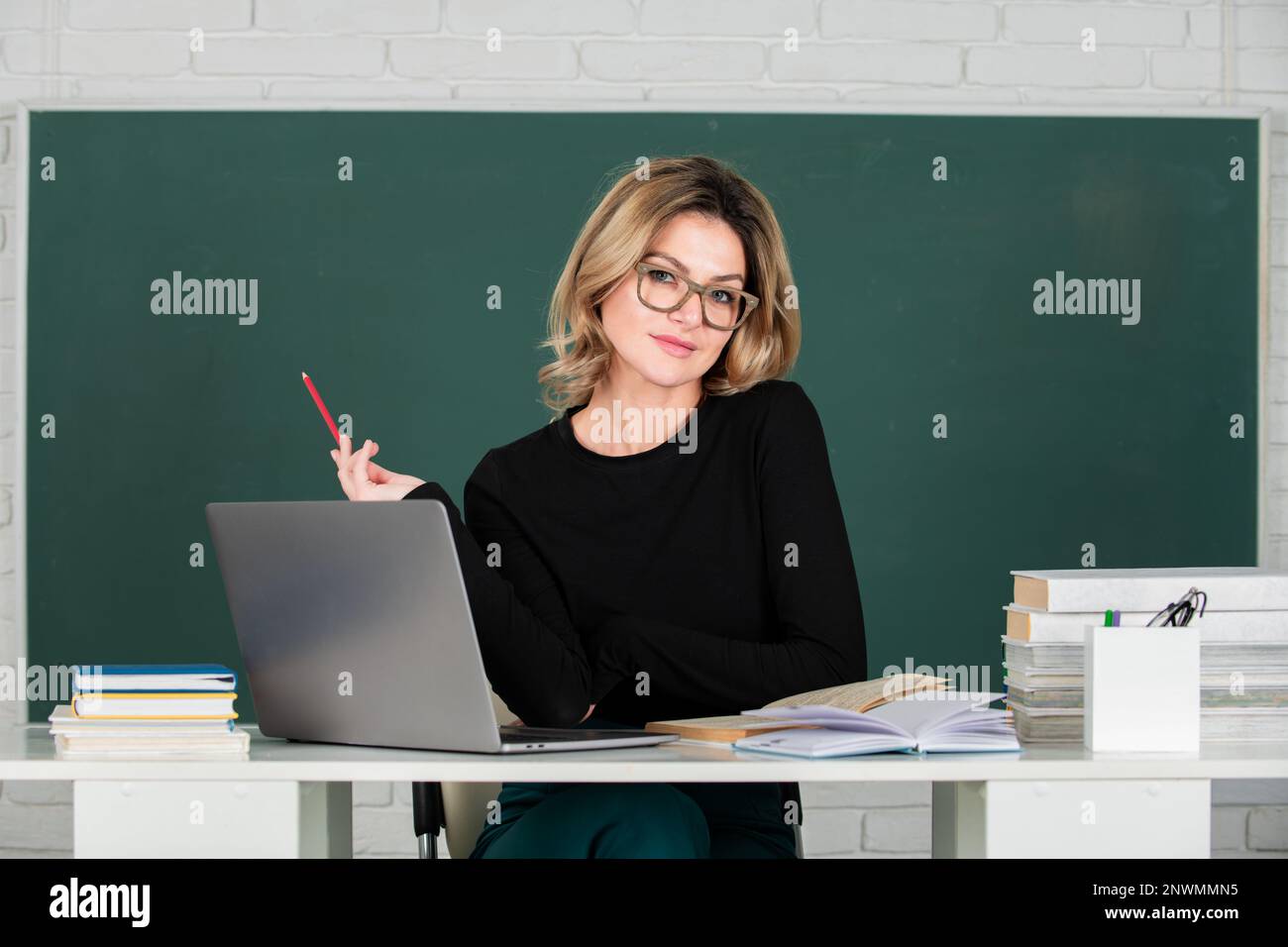Portrait of female beautiful teacher teaching high school students with ...