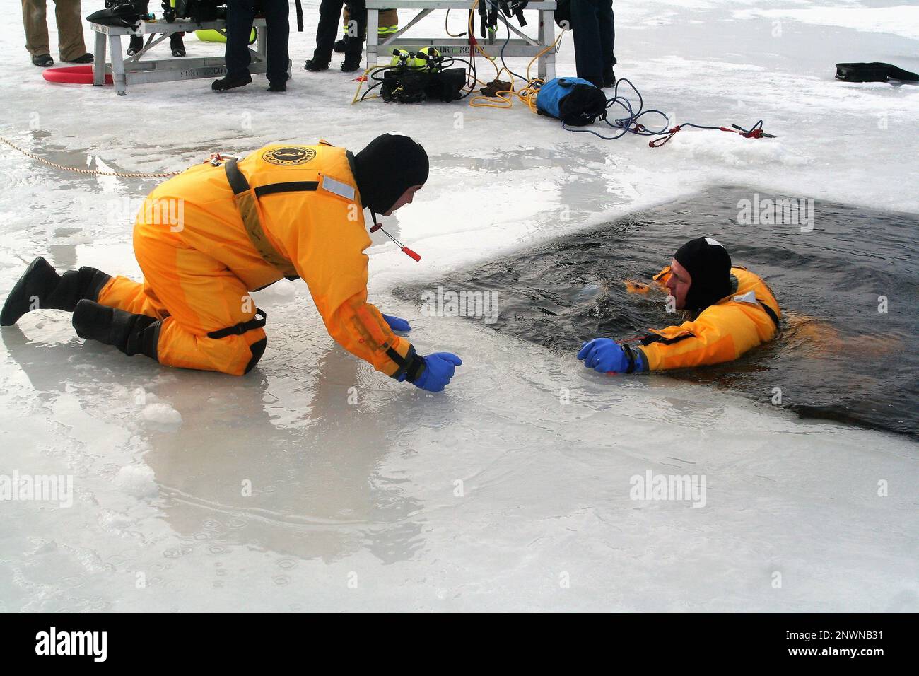 Firefighters wearing cold-water immersion protective suits hold surface ...