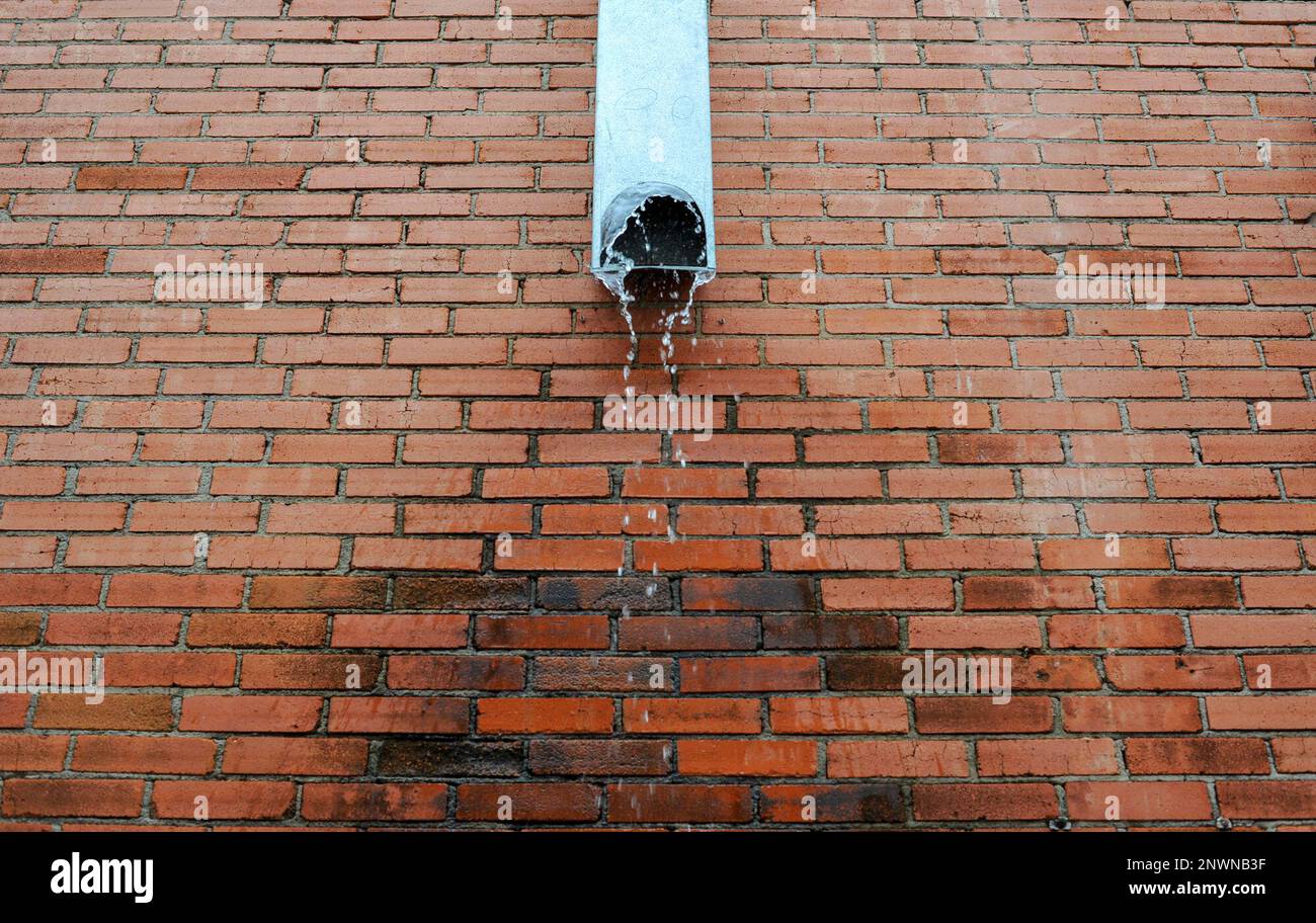 Water falls from a gutter spout following morning rain Monday, Sept. 10 ...