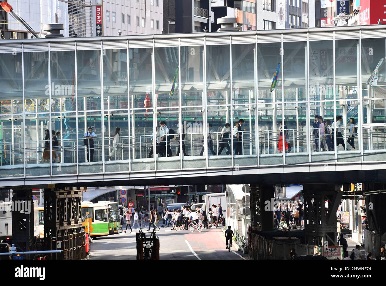 A picture shows passers-by walking at a connecting bridge between ...