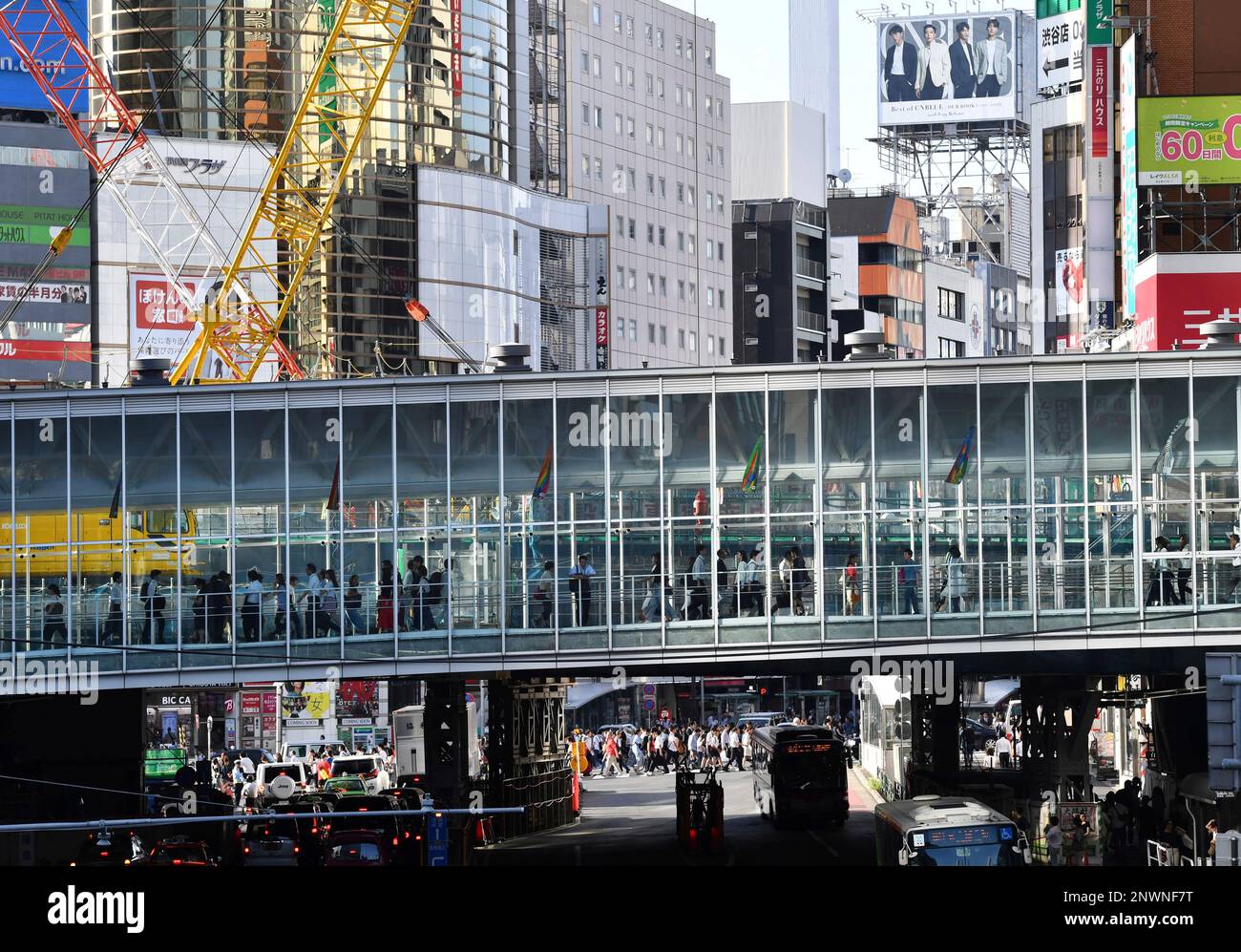 A picture shows passers-by walking at a connecting bridge between ...