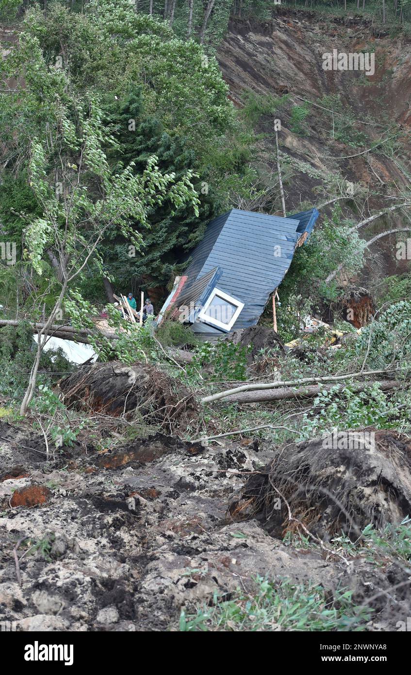 A collapsed house due to a landslide triggered by an earthquake is ...