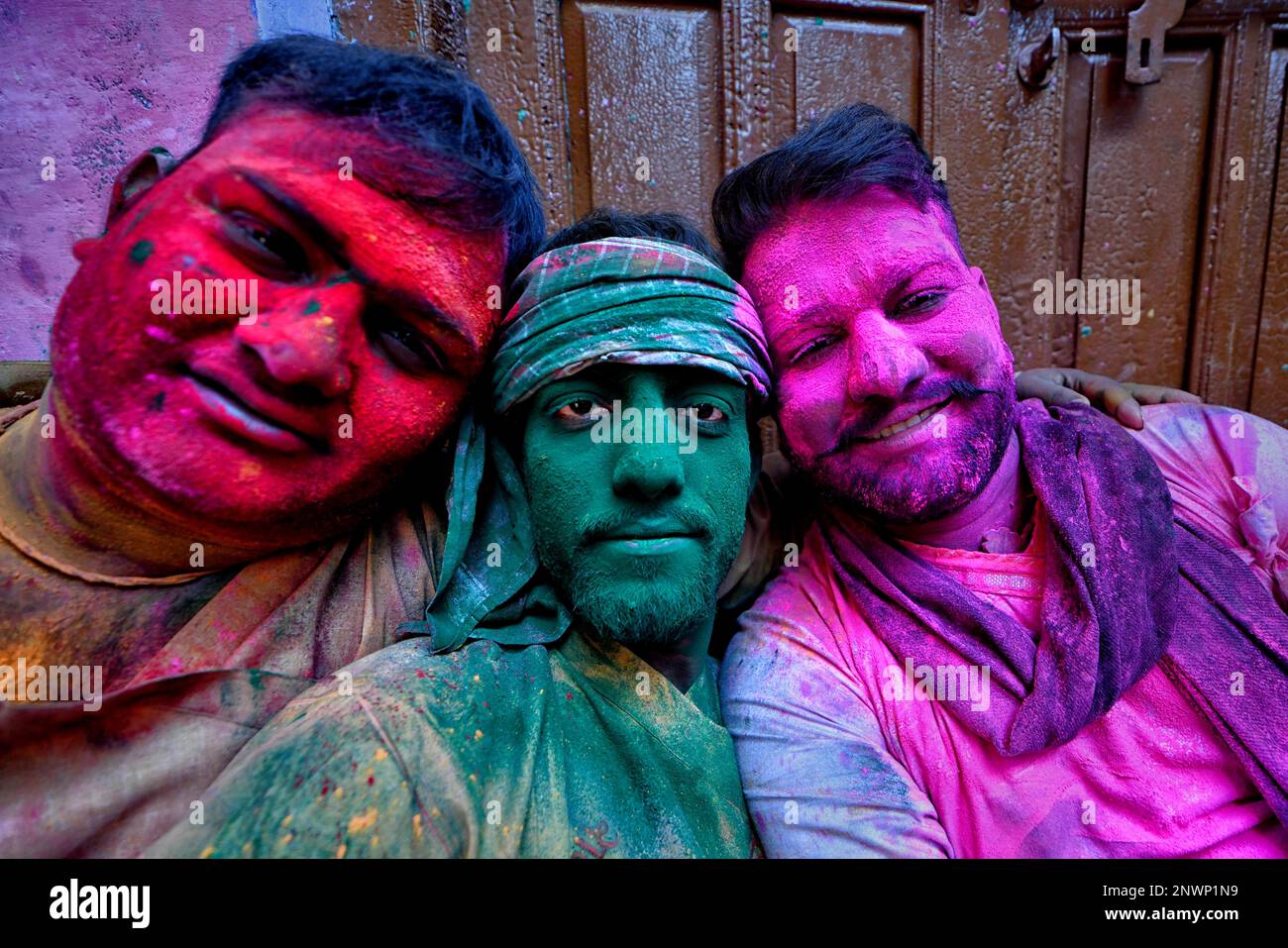 Devotees with colour all over, pose for a photo during the Lathmar Holi ...
