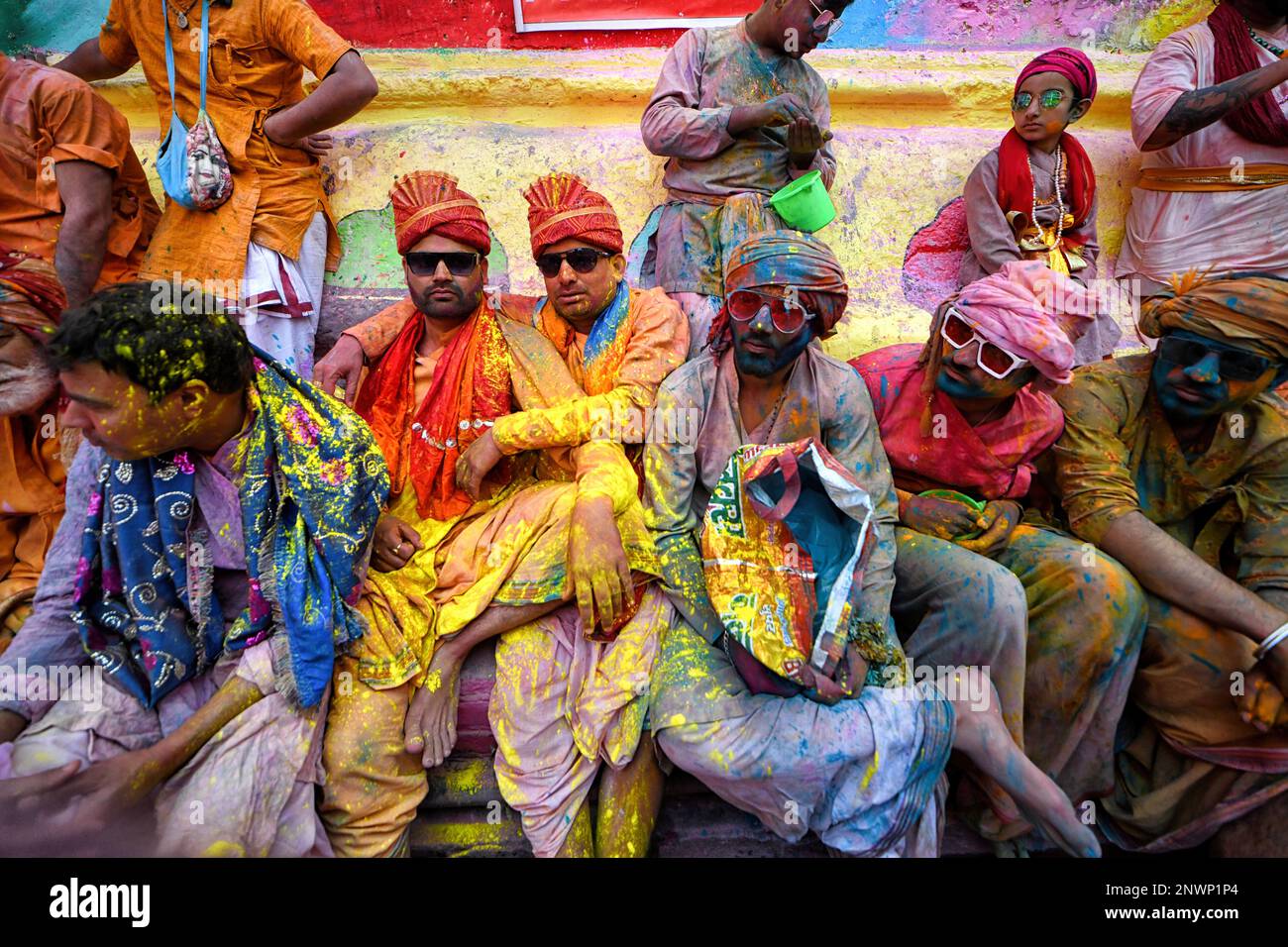 Devotees with colour all over, pose for a photo during the Lathmar Holi ...