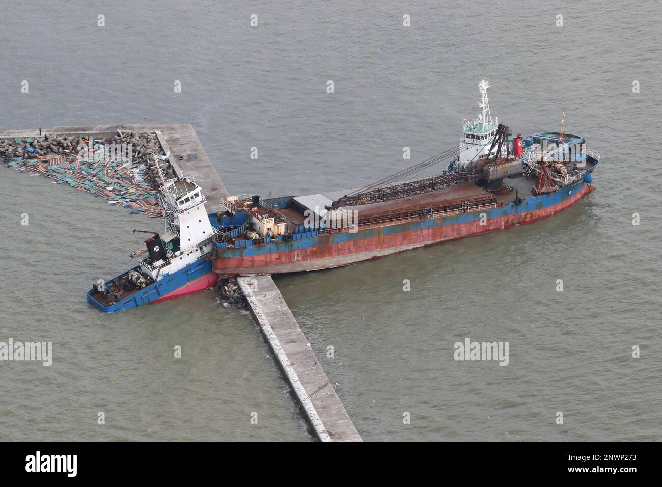 An aerial photo shows a vessel aground on a breakwater due to strong ...