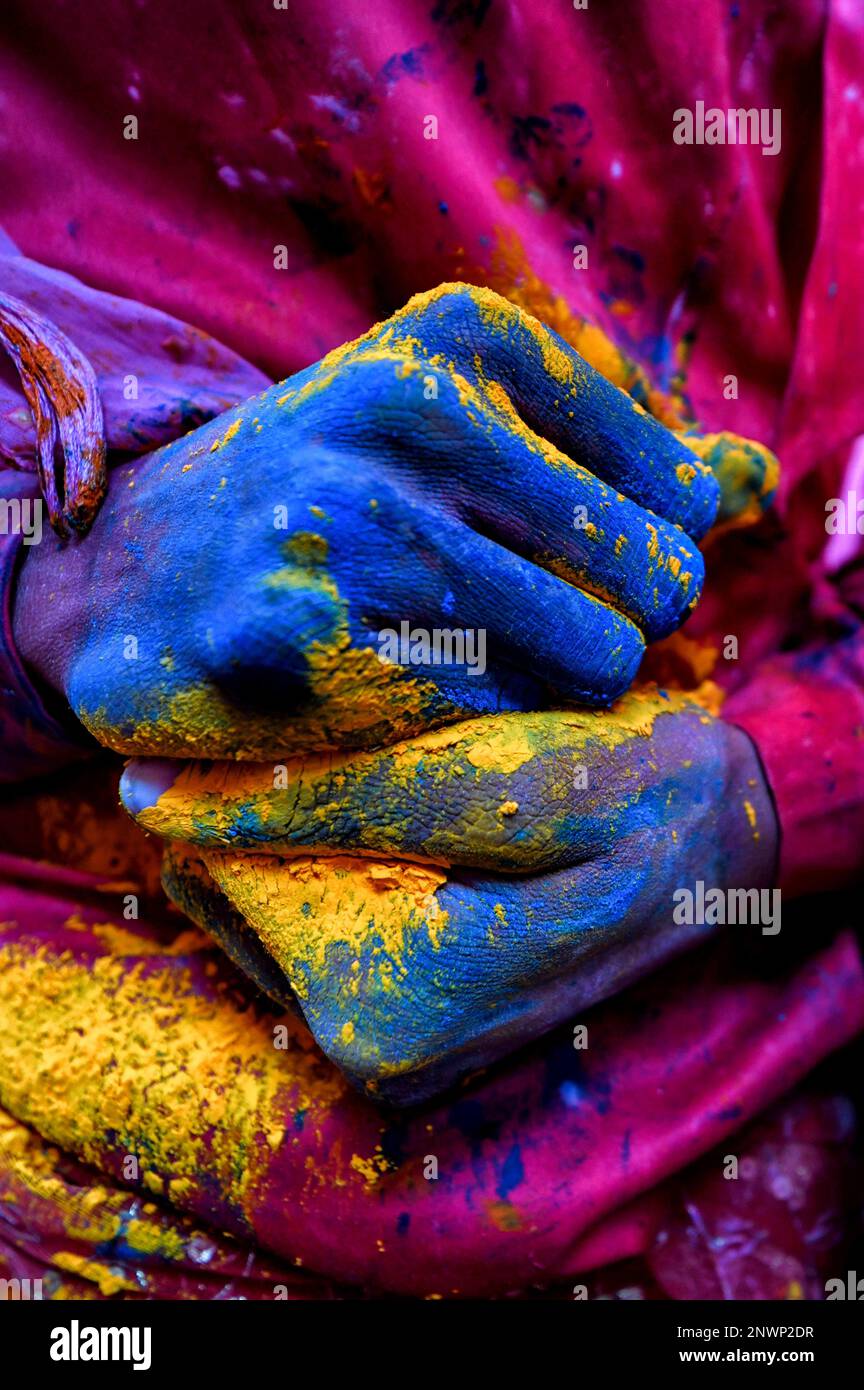 A devotee with colorful powders prepares during the Lathmar Holi ...