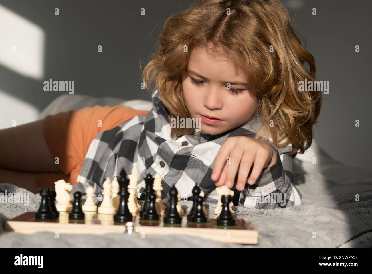 Child playing chess at home. Clever concentrated and thinking child ...