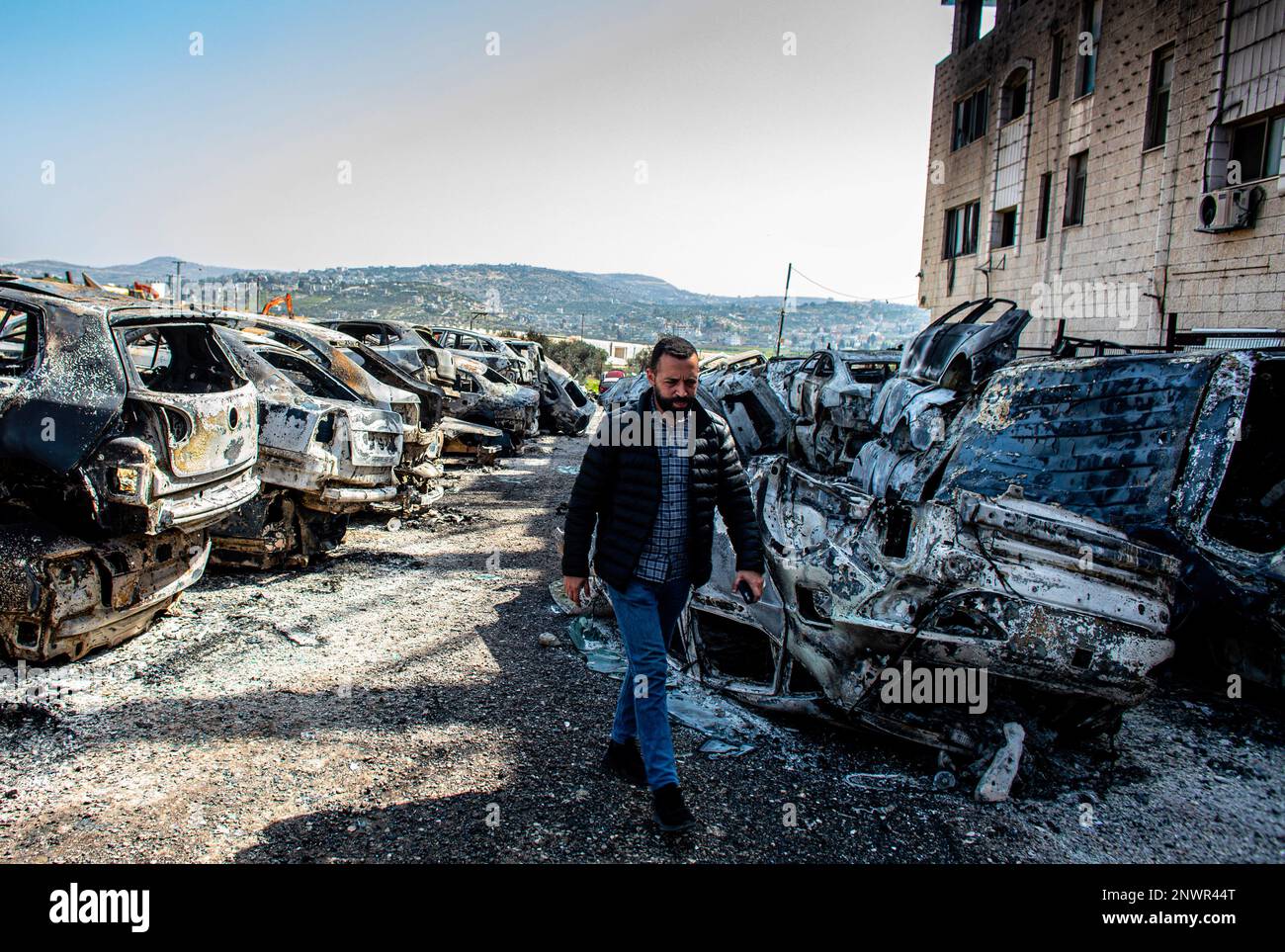 Huwara, Israel. 28th Feb, 2023. A Palestinian man walks between torched ...