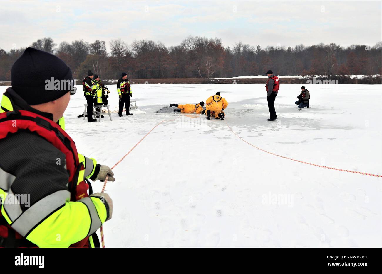 Firefighters wearing cold-water immersion protective suits hold surface ...