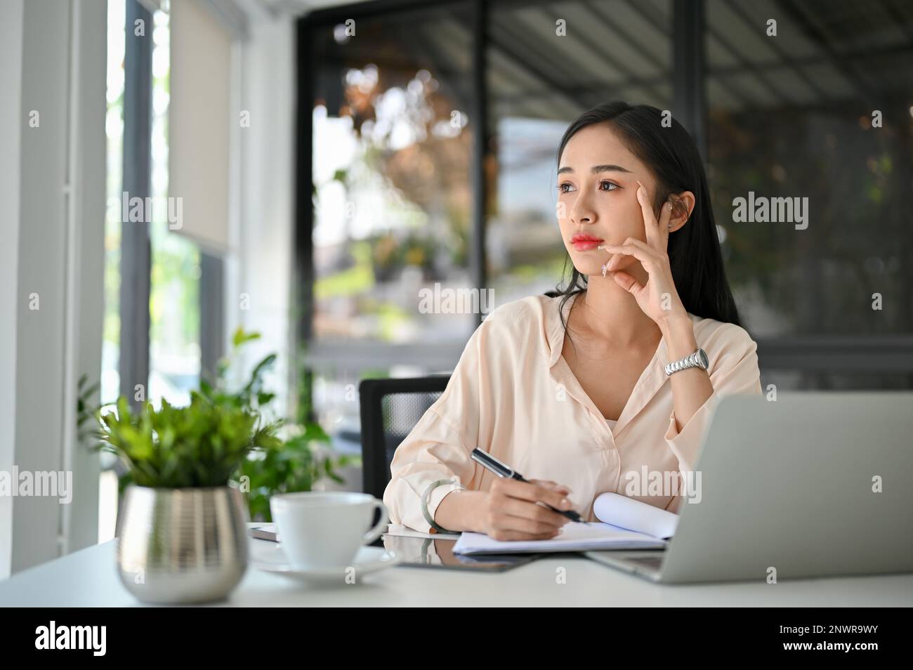 Thoughtful millennial Asian businesswoman or female manager is looking ...