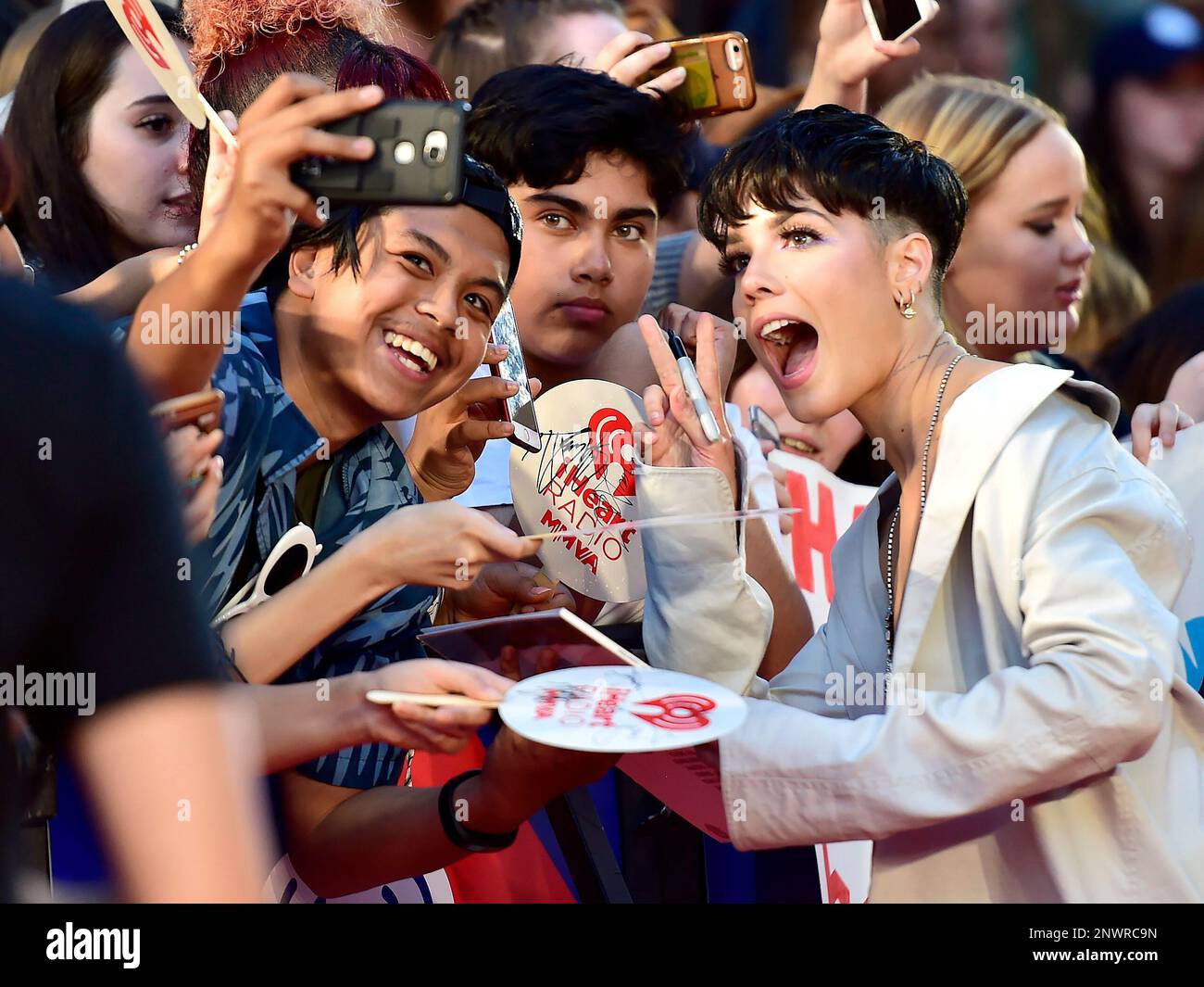 Halsey poses for photos with fans as she arrives on the red carpet at ...