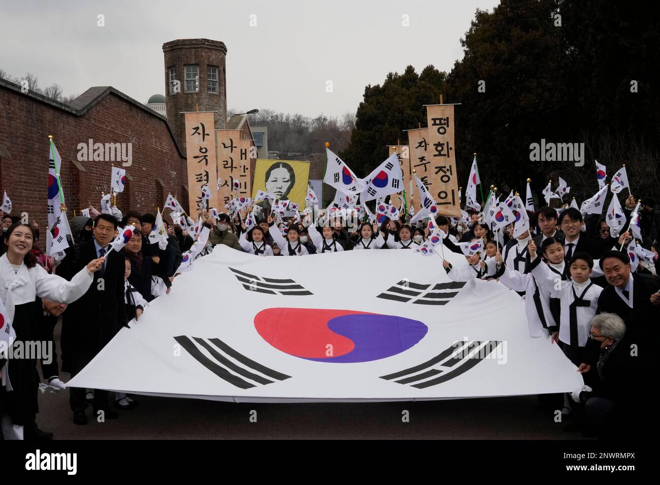 South Koreans wave national flags as they march during a ceremony to ...