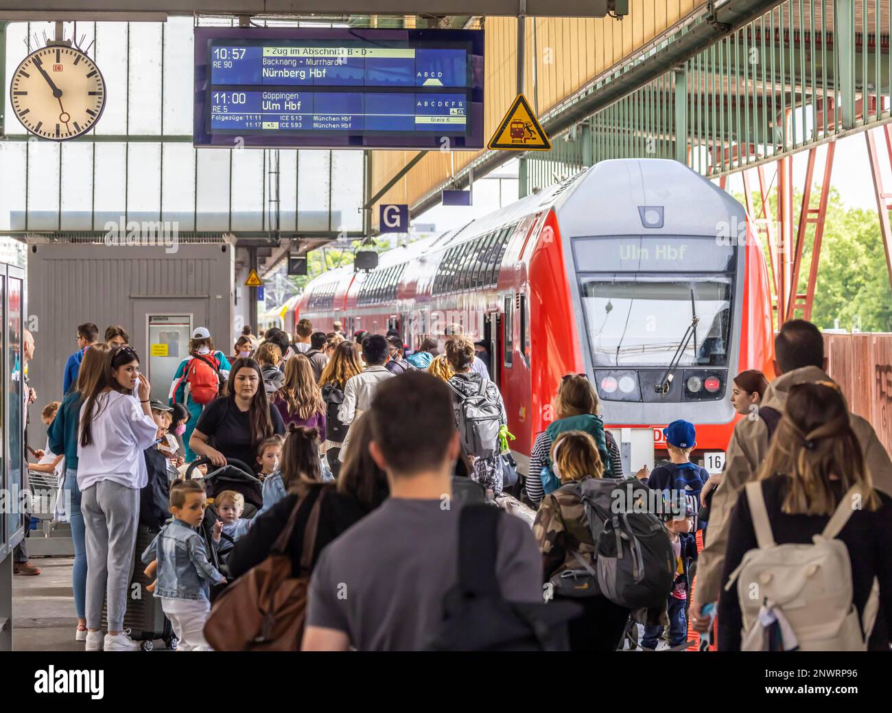 Many people travelling, waiting for their train at the main station ...