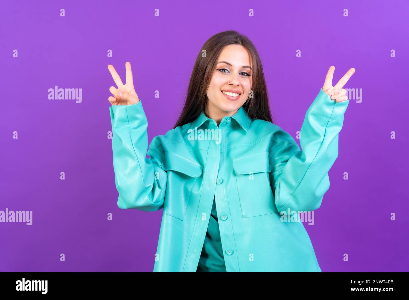Young woman isolated on purple background smiling and showing victory ...