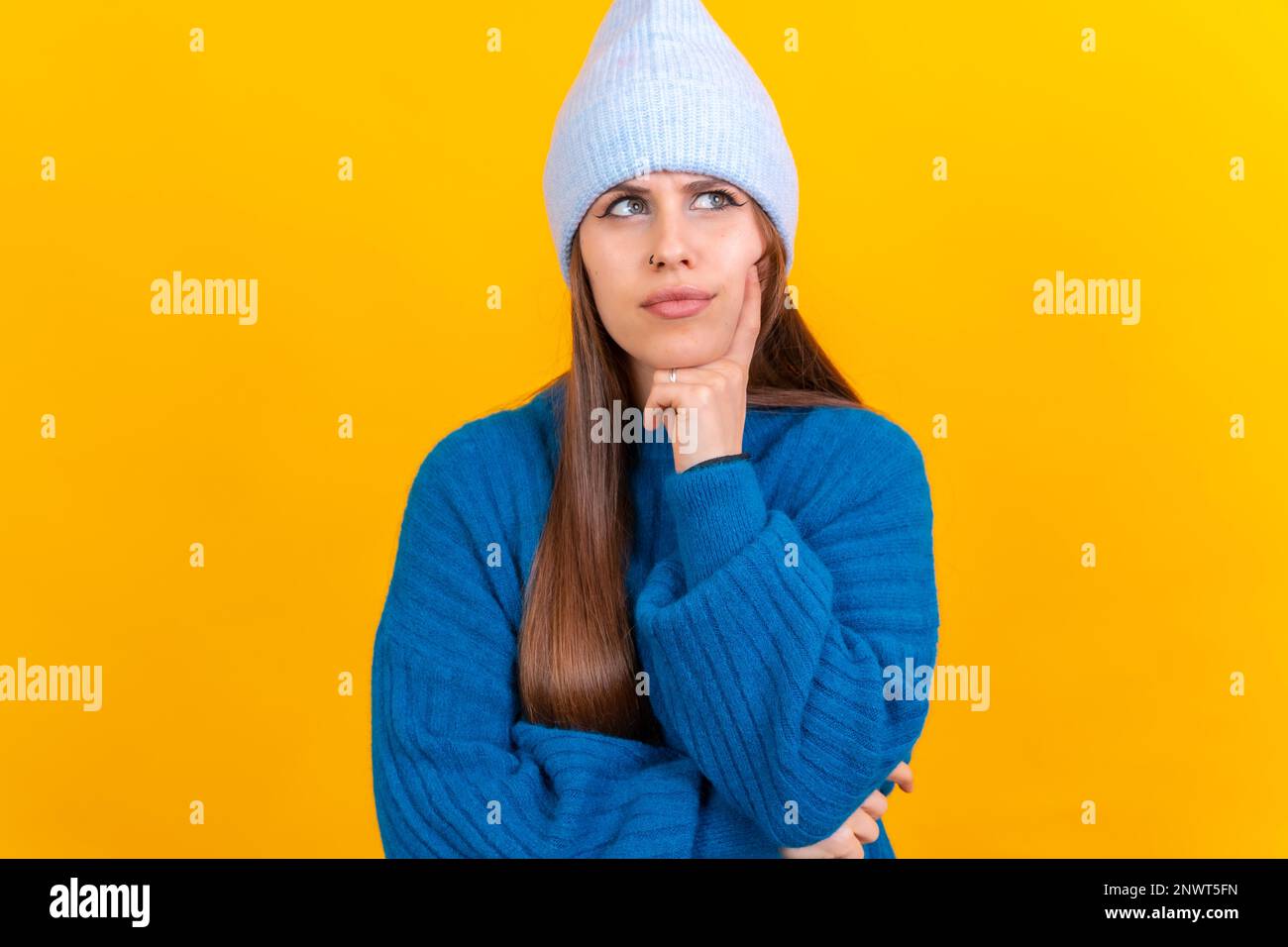 Thinking woman with many ideas with copyspace over yellow background ...