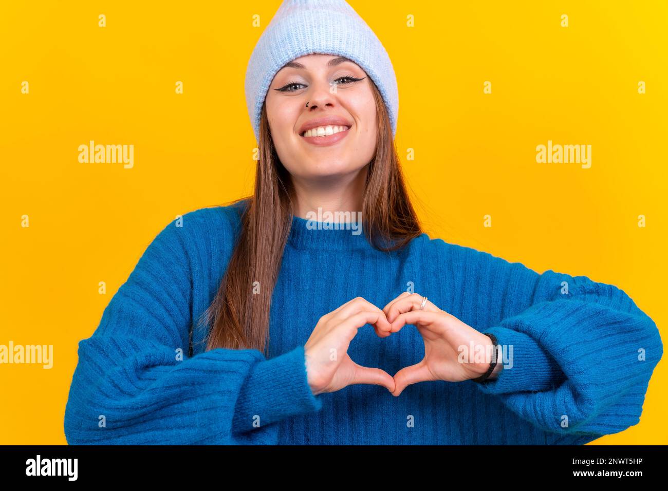 Young brunette woman wearing blue sweater over isolated yellow ...