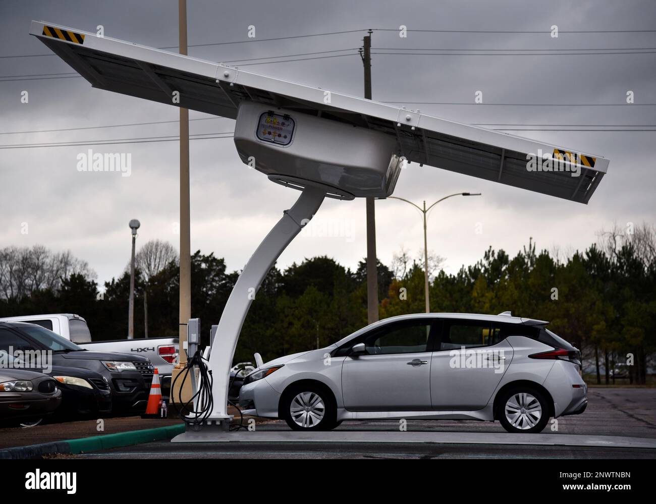 An electric vehicle charges its battery at one of the seven solar ...