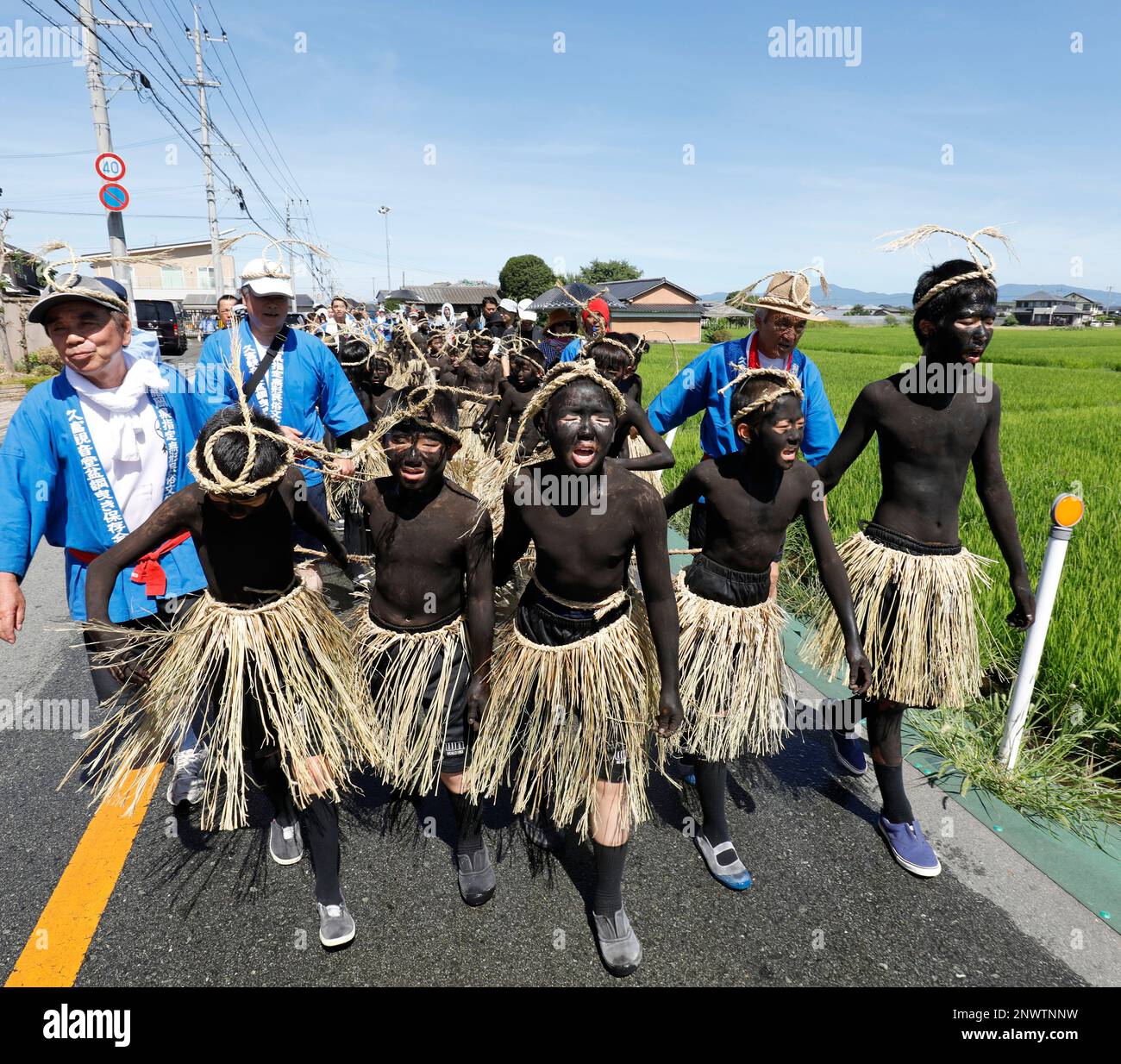 Children, wearing a straw-demons style, walk around the streets drawing ...