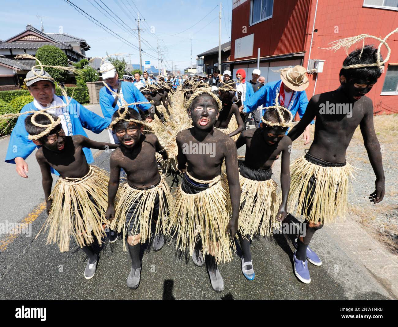 Children, wearing a straw-demons style, walk around the streets drawing ...