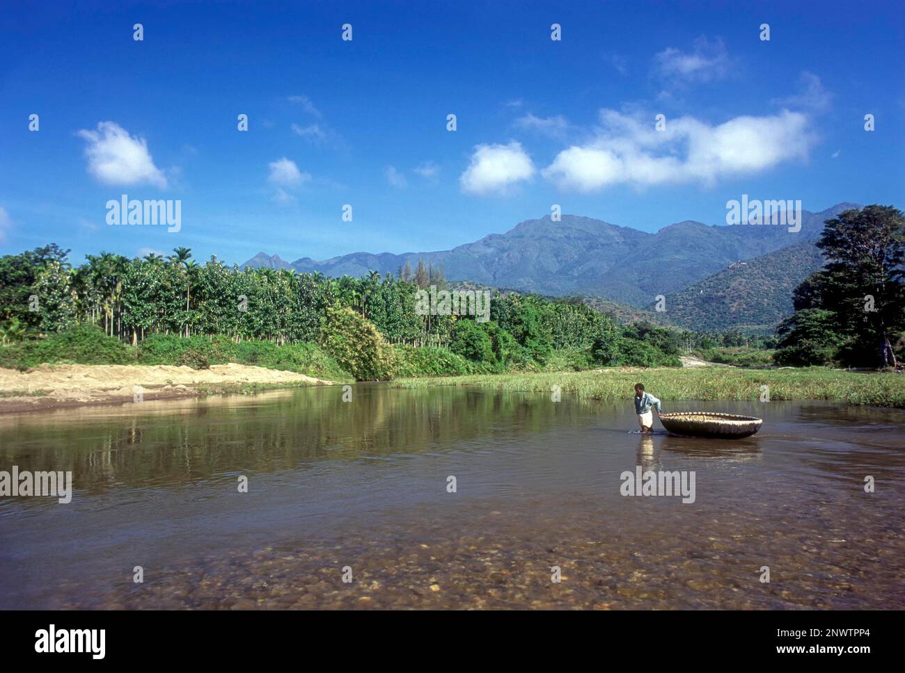 A man pulling the coracle on the Bhavani river in Attappadi, Kerala ...