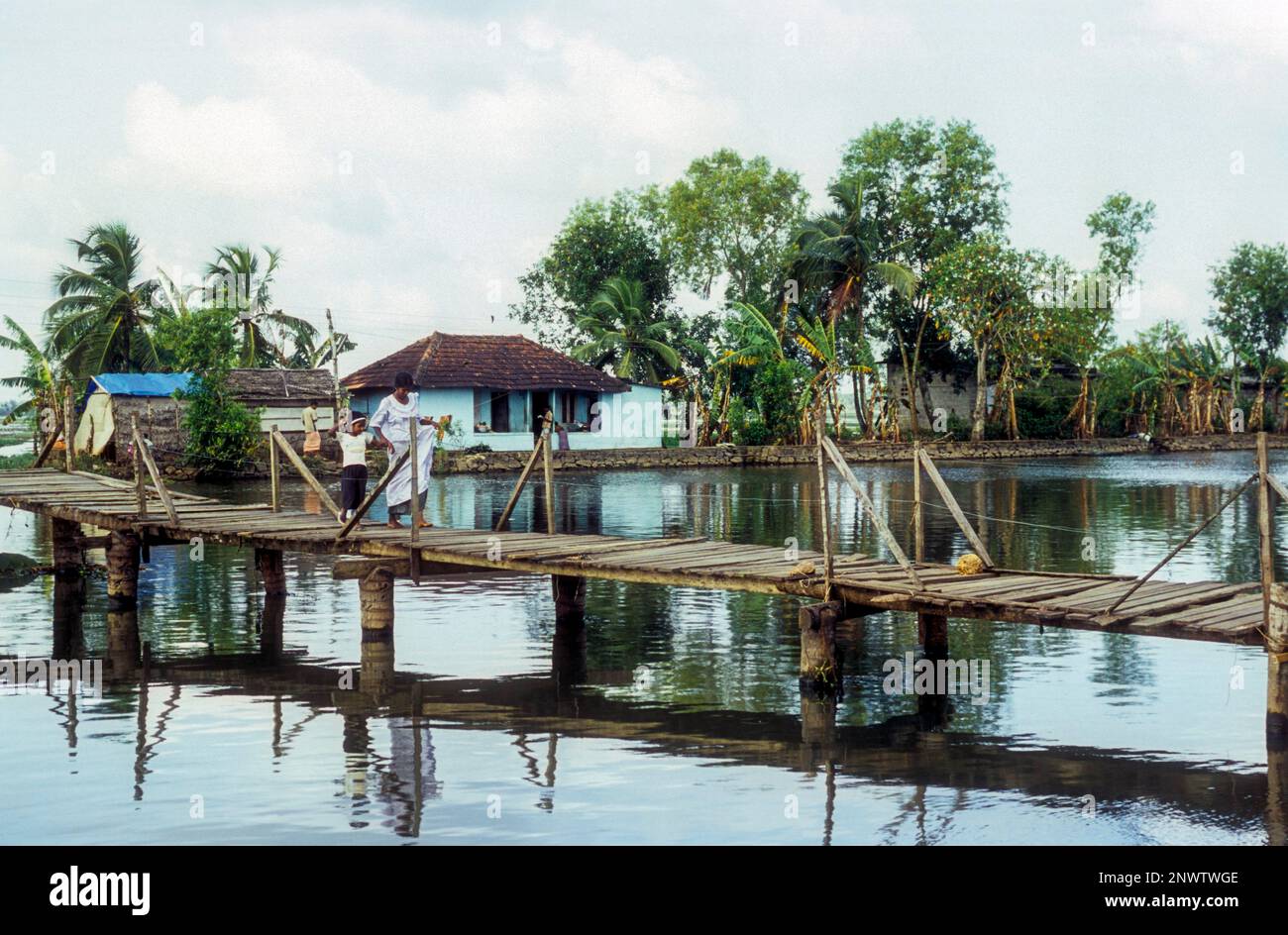 A scene of people crossing the backwater on the wooden bridge located ...