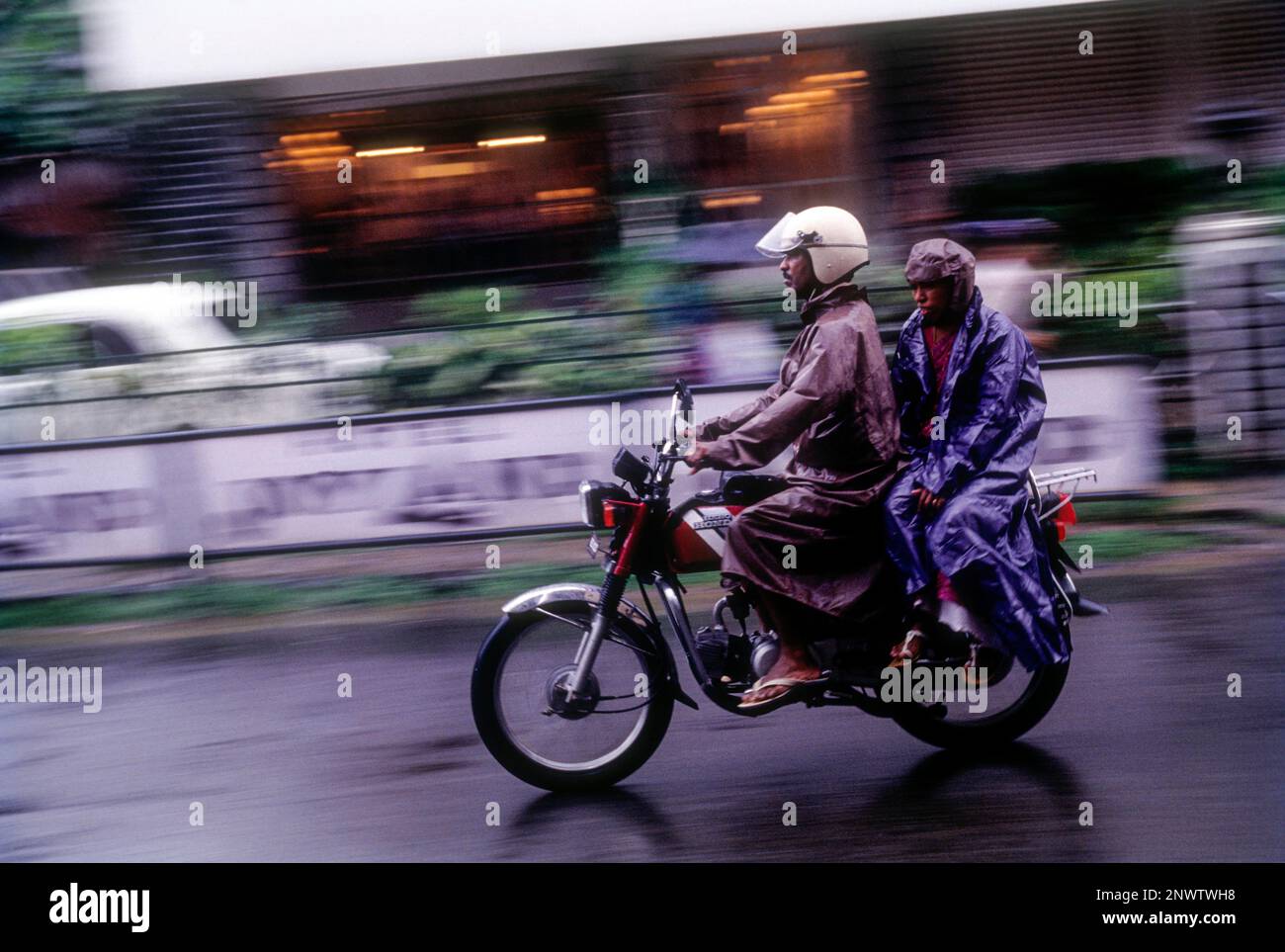 A couple riding motorcycle on a rainy day at Ernakulam, Kochi, Kerala ...