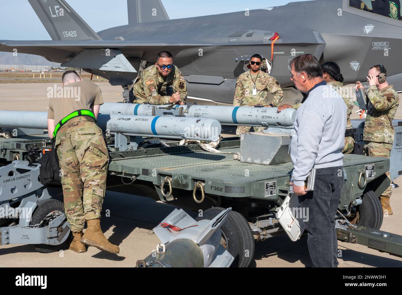 Airmen assigned to the 308th Aircraft Maintenance Unit prepare an AIM ...