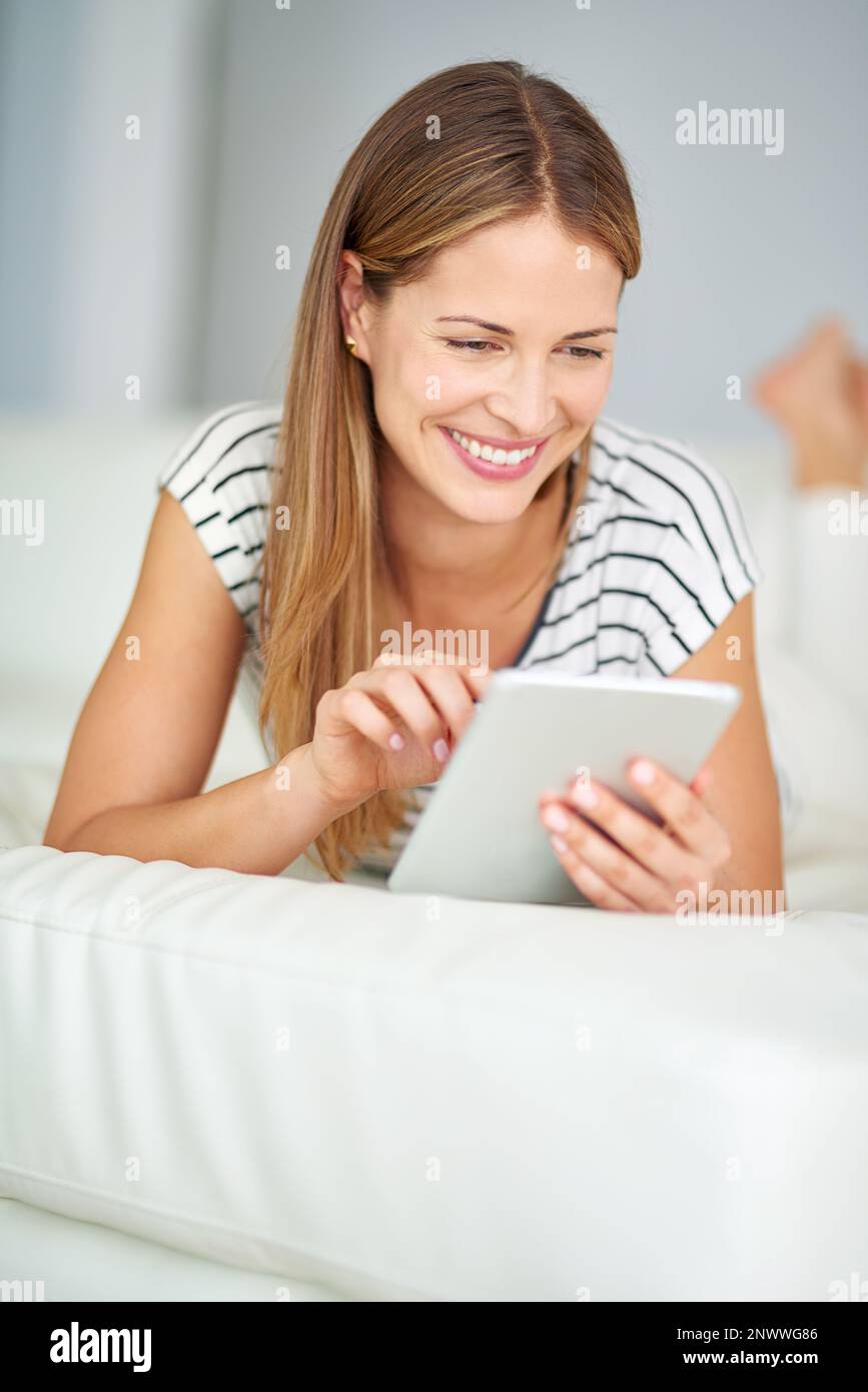 Staying entertained online. a young woman browsing the internet at home ...