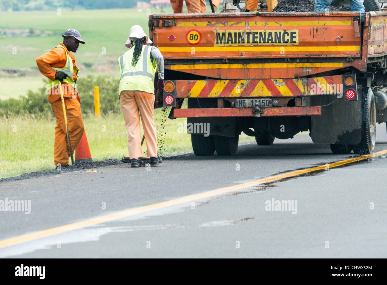 road maintenance truck or lorry with workers or employees working on repairing road ...