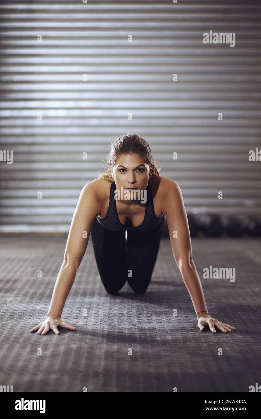 Embrace the struggle and stay focused. a young woman doing push-ups at ...