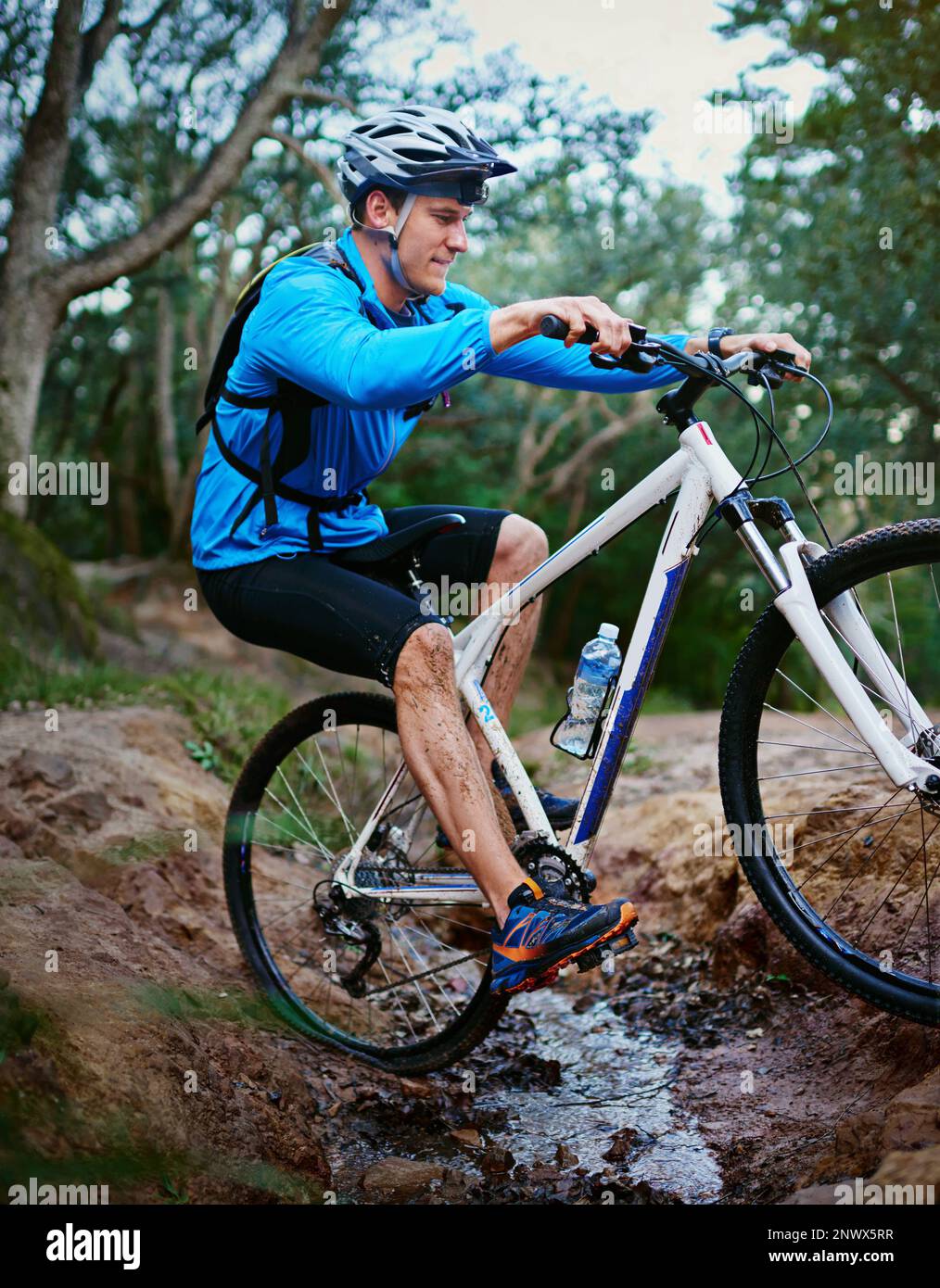 Taking on a tough trail. a male cyclist riding along a mountain bike ...