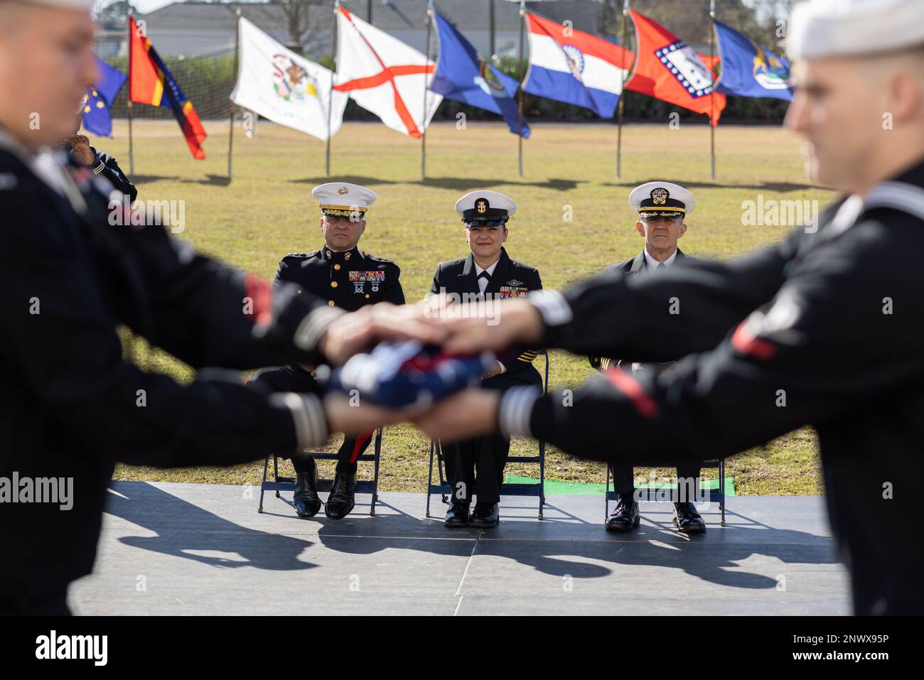 U.S. Sailors prepare the flag for presentation during a retirement ...