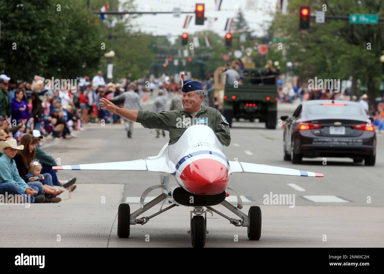 Harold Reed waves to the crowd from a toy Thunderbird plane during the ...