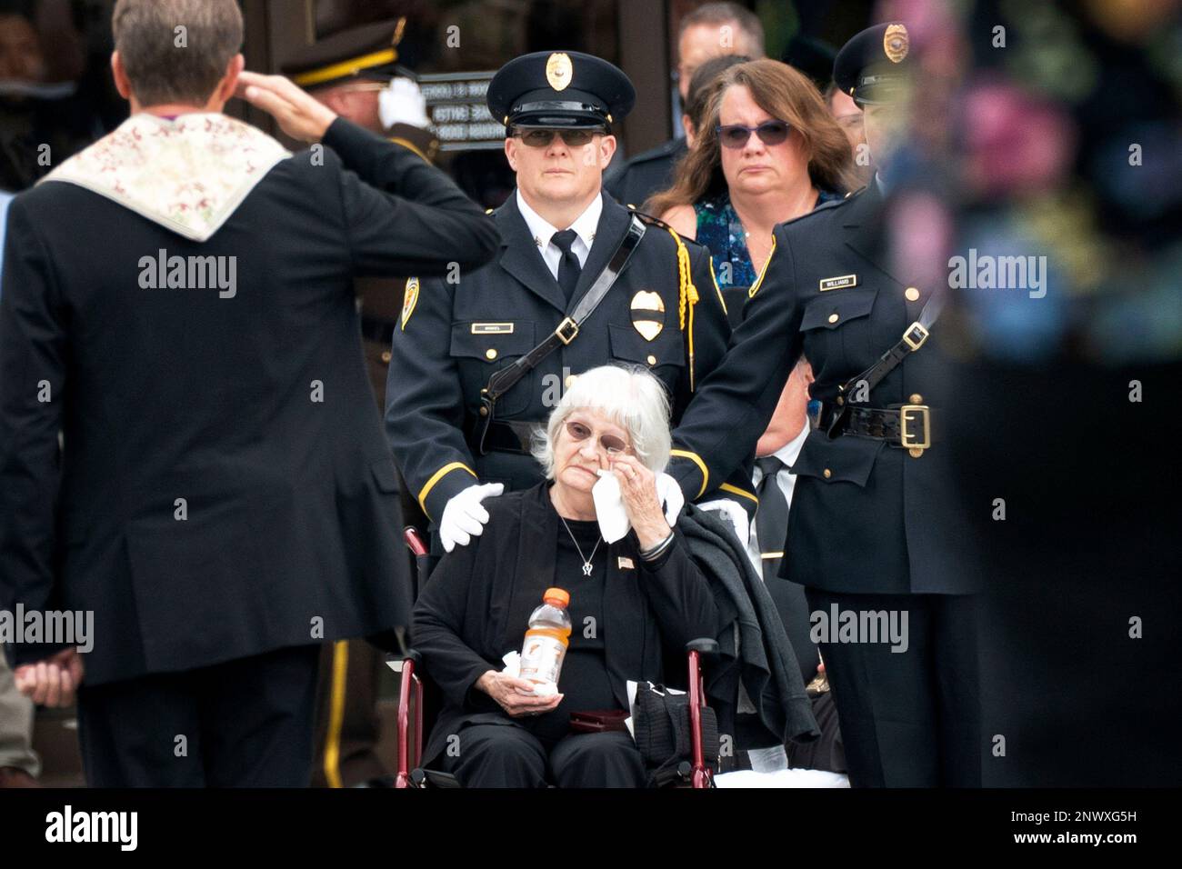 Gloria Gomm, mother of Officer Joseph Gomm, wipes a tear as her son's ...