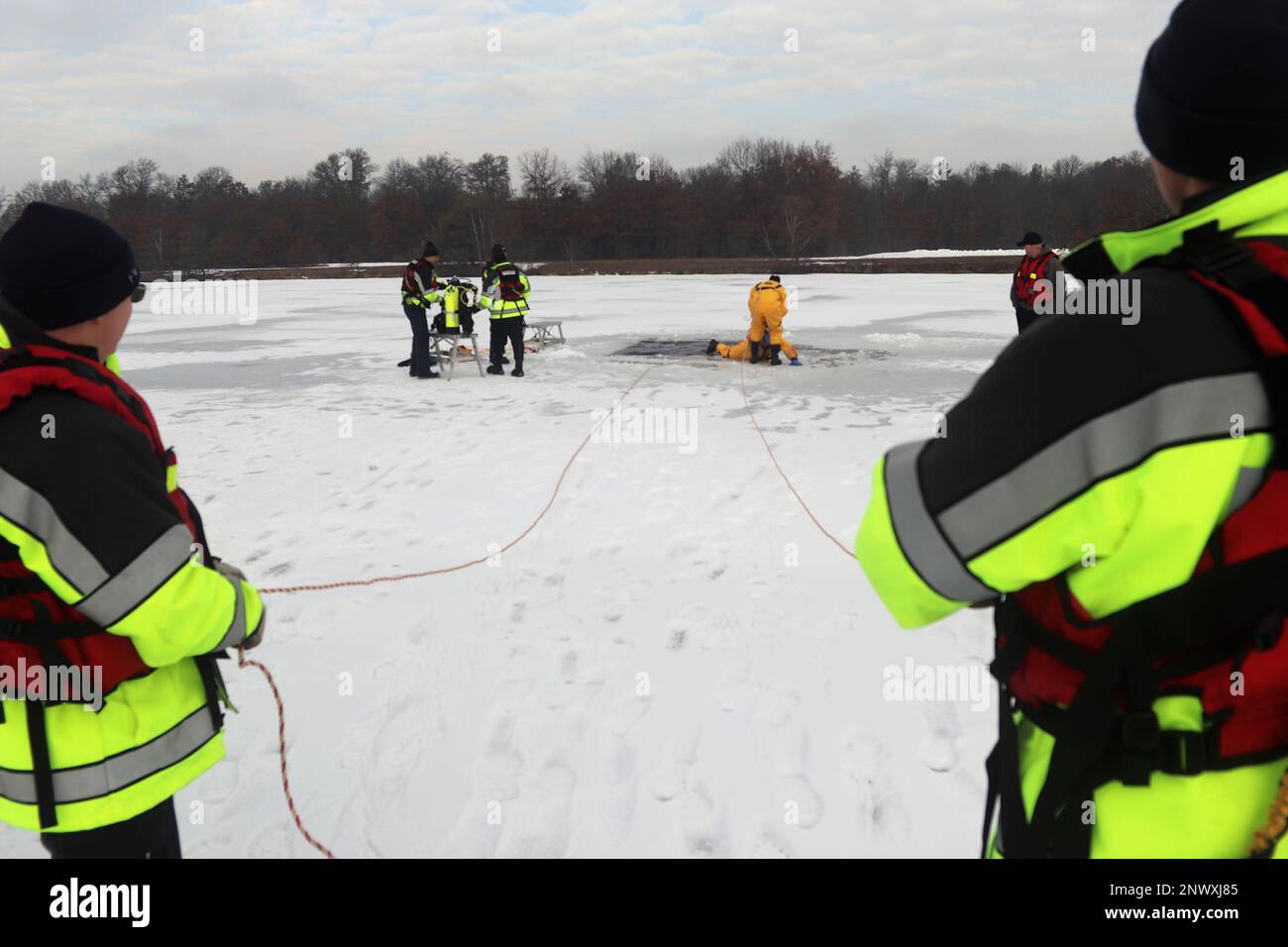 Firefighters wearing cold-water immersion protective suits hold surface ...