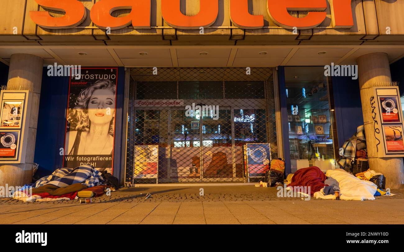 Munich, Germany. 01st Mar, 2023. Homeless people sleep in the entrance ...