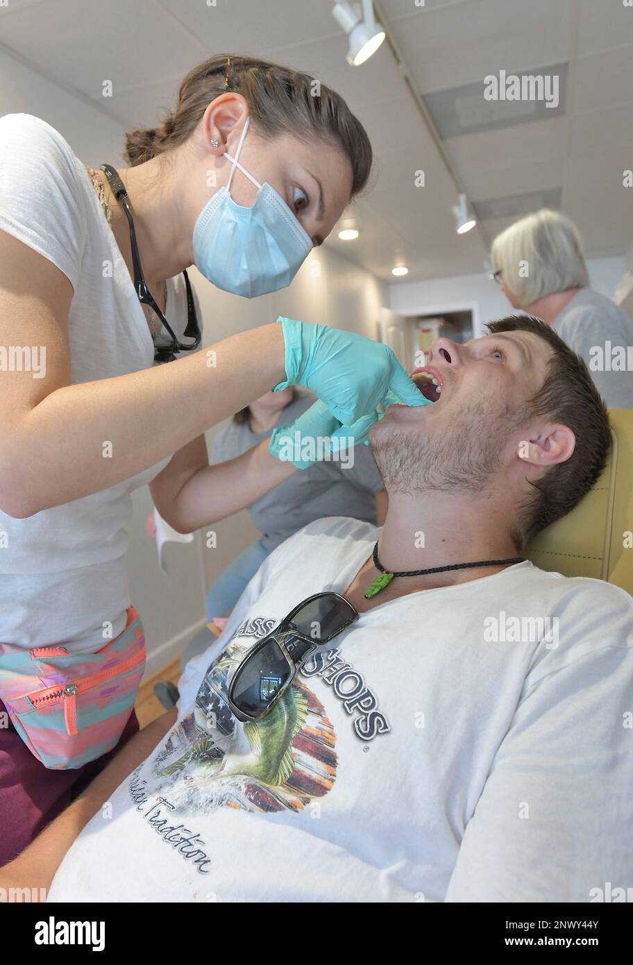 Solomia Zhownirovych, DDS., from New York, looks into the mouth of Adam ...
