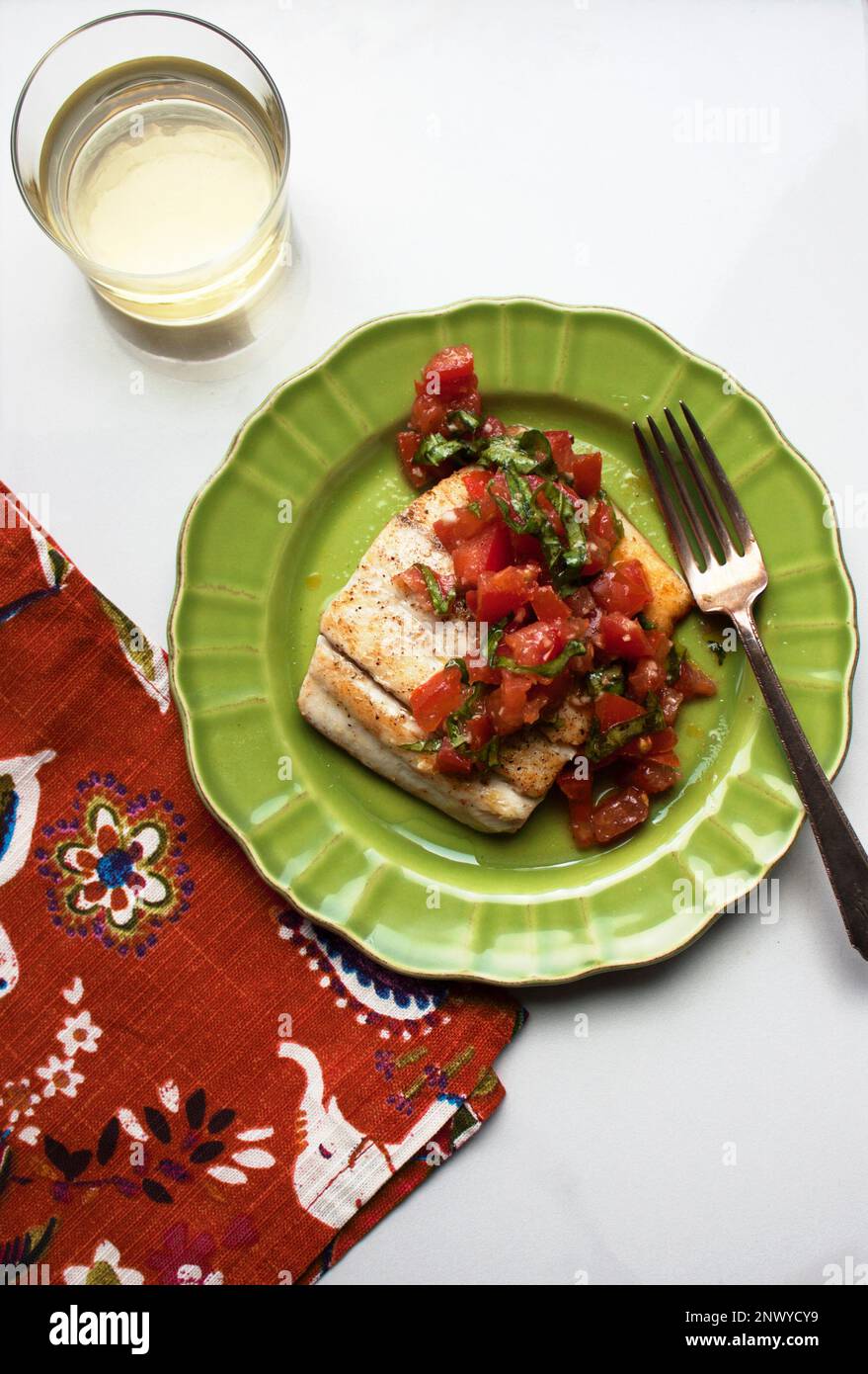 This May 2017 photo shows pan seared fish with tomato basil relish in ...