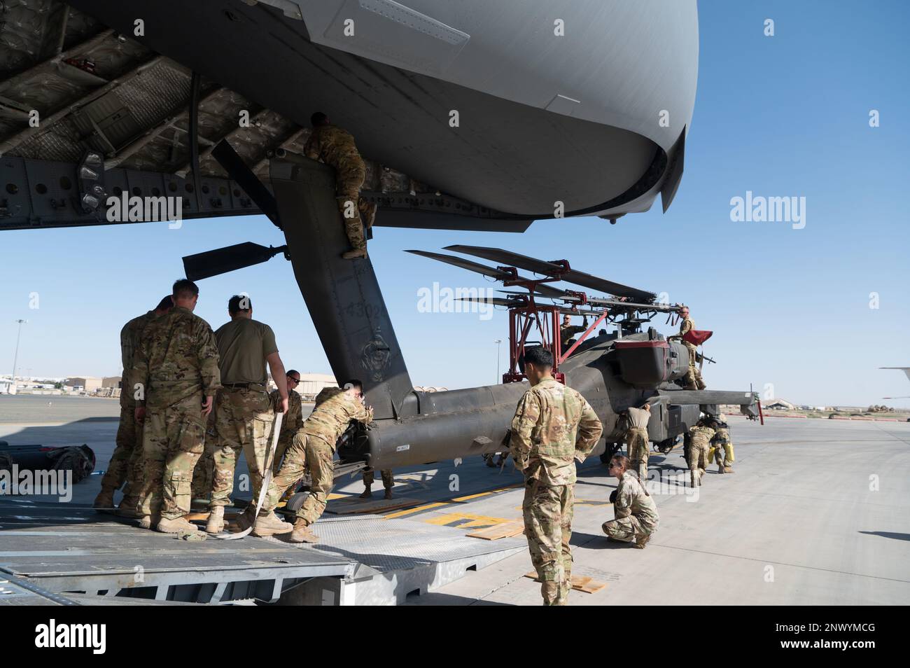 U.S. Airmen and Soldiers offload an AH-64D Apache Longbow helicopter ...