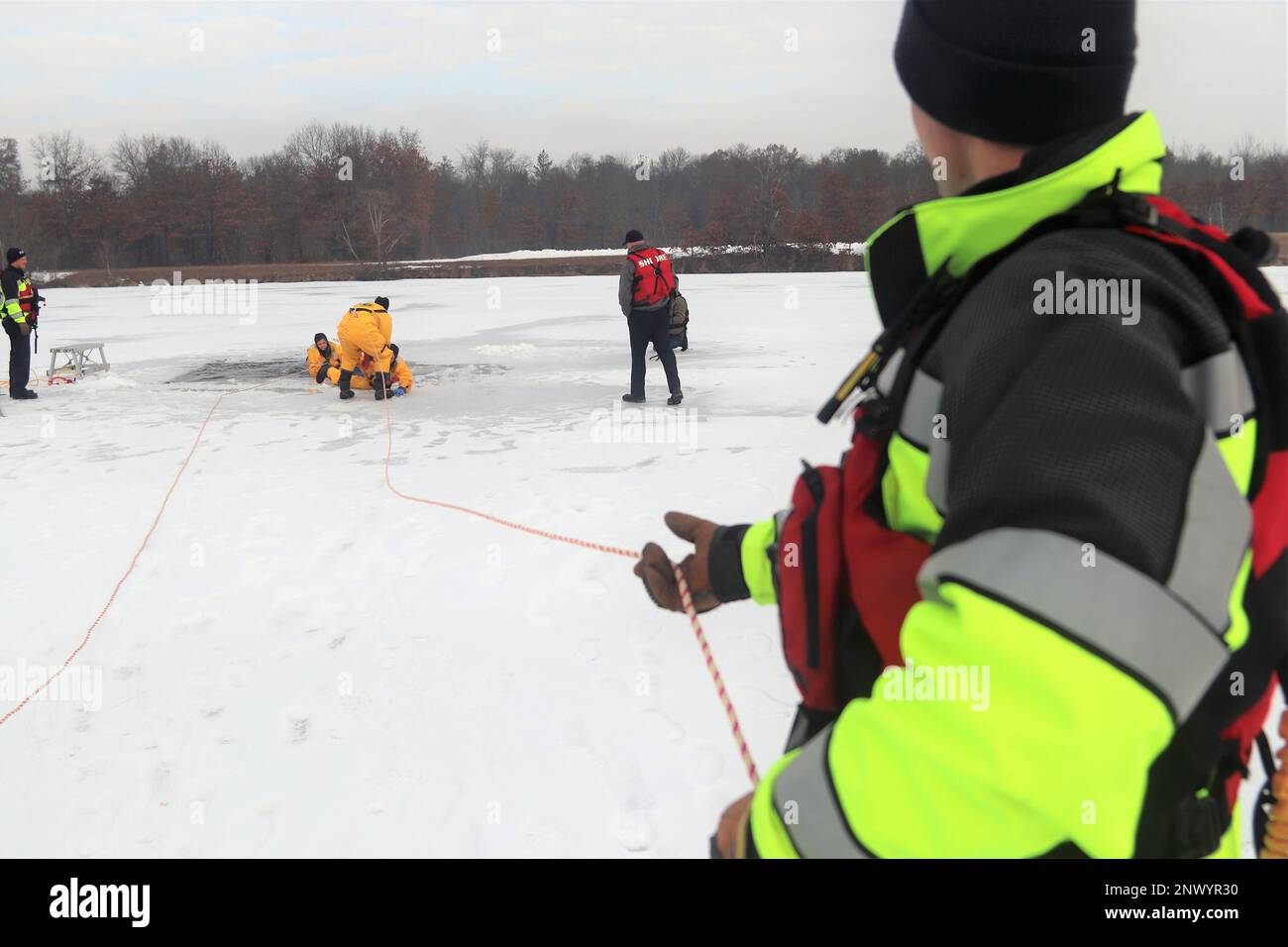 Firefighters wearing cold-water immersion protective suits hold surface ...