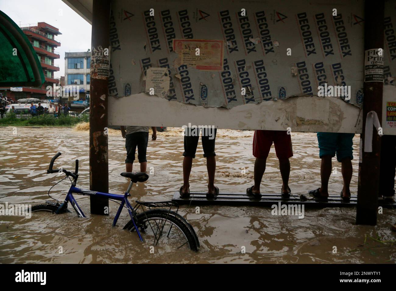 Nepalese stand atop of a bench in a flooded area in Bhaktapur, Nepal ...